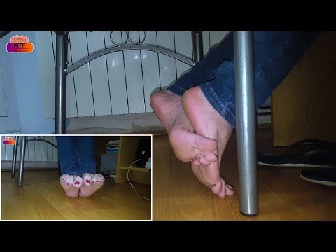 Gorgeous bare feet in jeans under chair