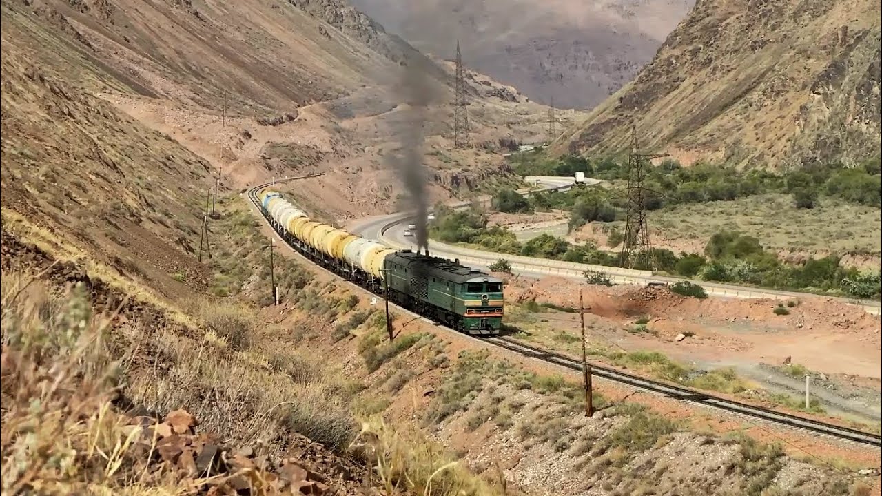 Diesel locomotive 2TE10V-4661 with a train of liquid tanks is moving ...