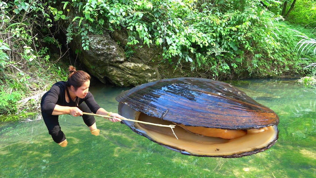The girl picked up several large pink clams and opened them, which were ...