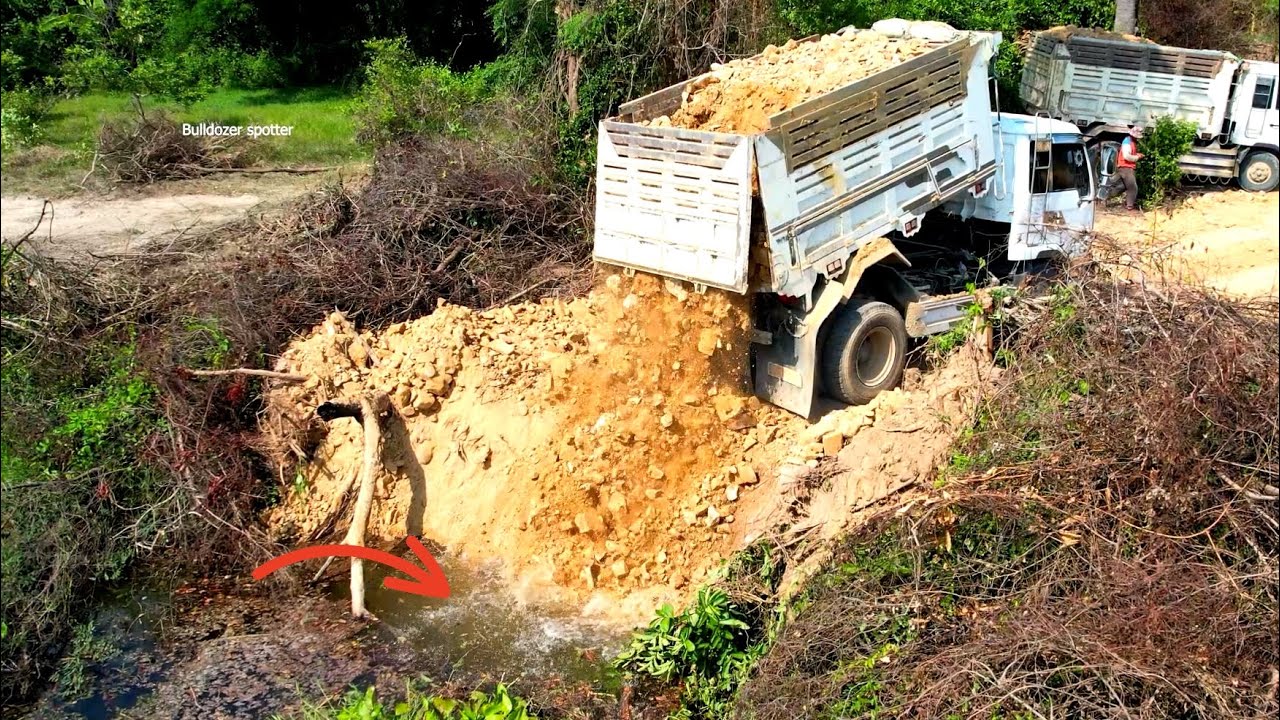 Wonderful First dump truck unloading stone into the build new road and ...