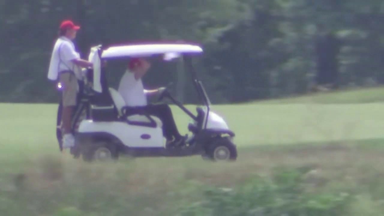 Trump seen driving golf cart as caddy clings on the back. - YouTube
