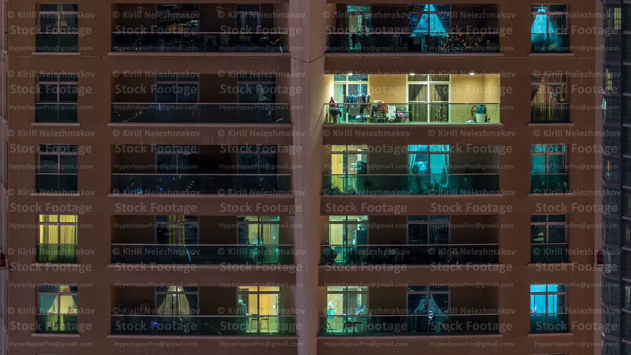 Glowing windows in multistory modern glass residential building light ...