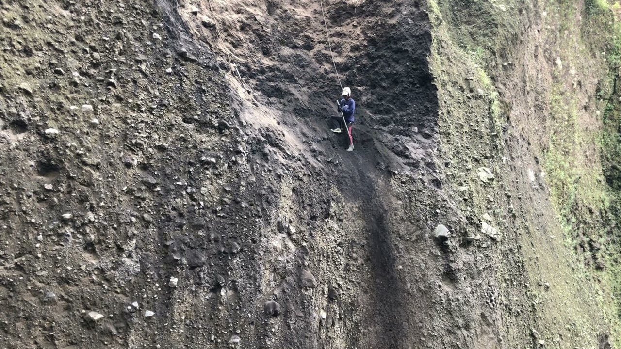 a brave miners mining sand on a cliff by himself - YouTube