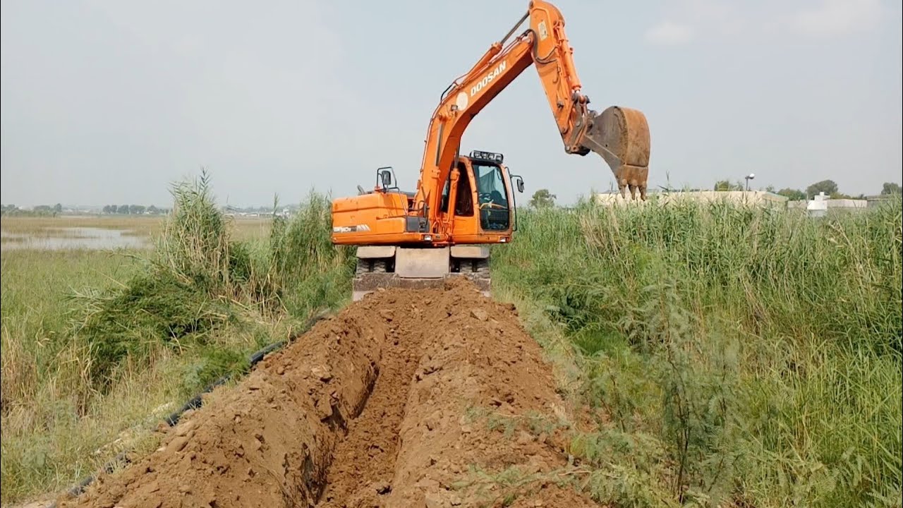 DX 140wd Excevater Machine Digging of water line at the bank of lake ...