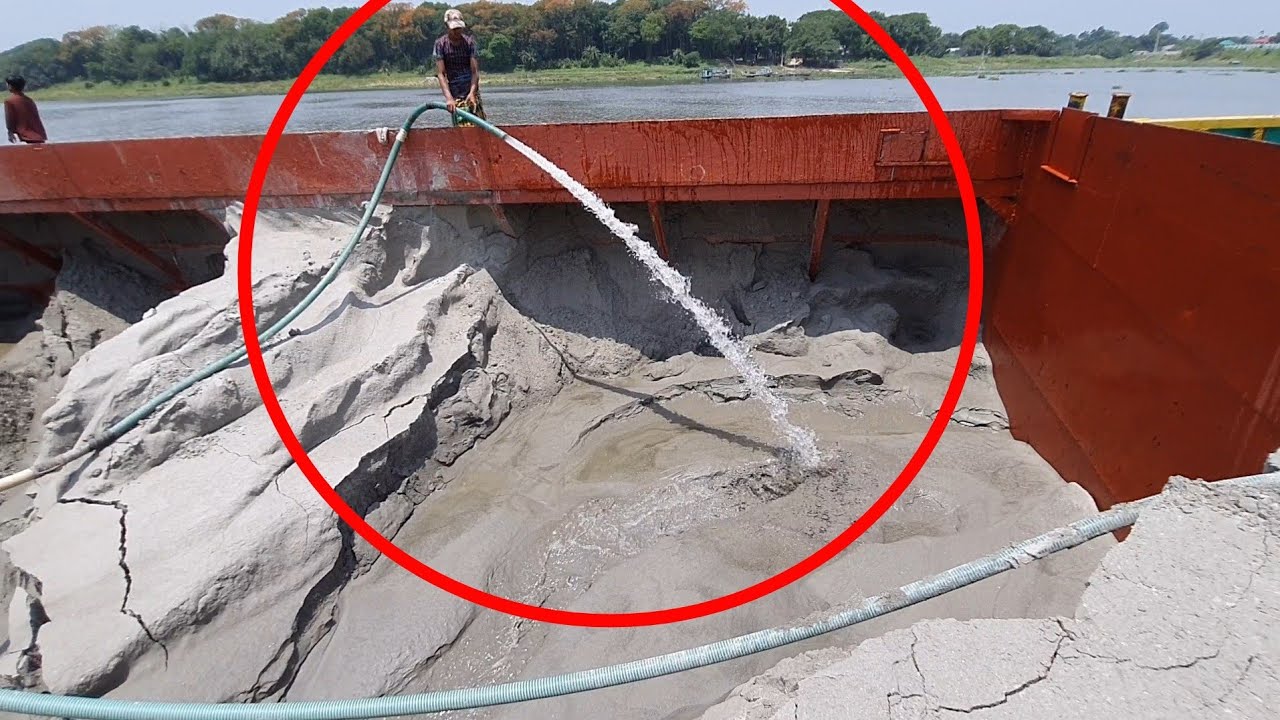 Sand is being unloaded from large ships with powerful dredger machines ...