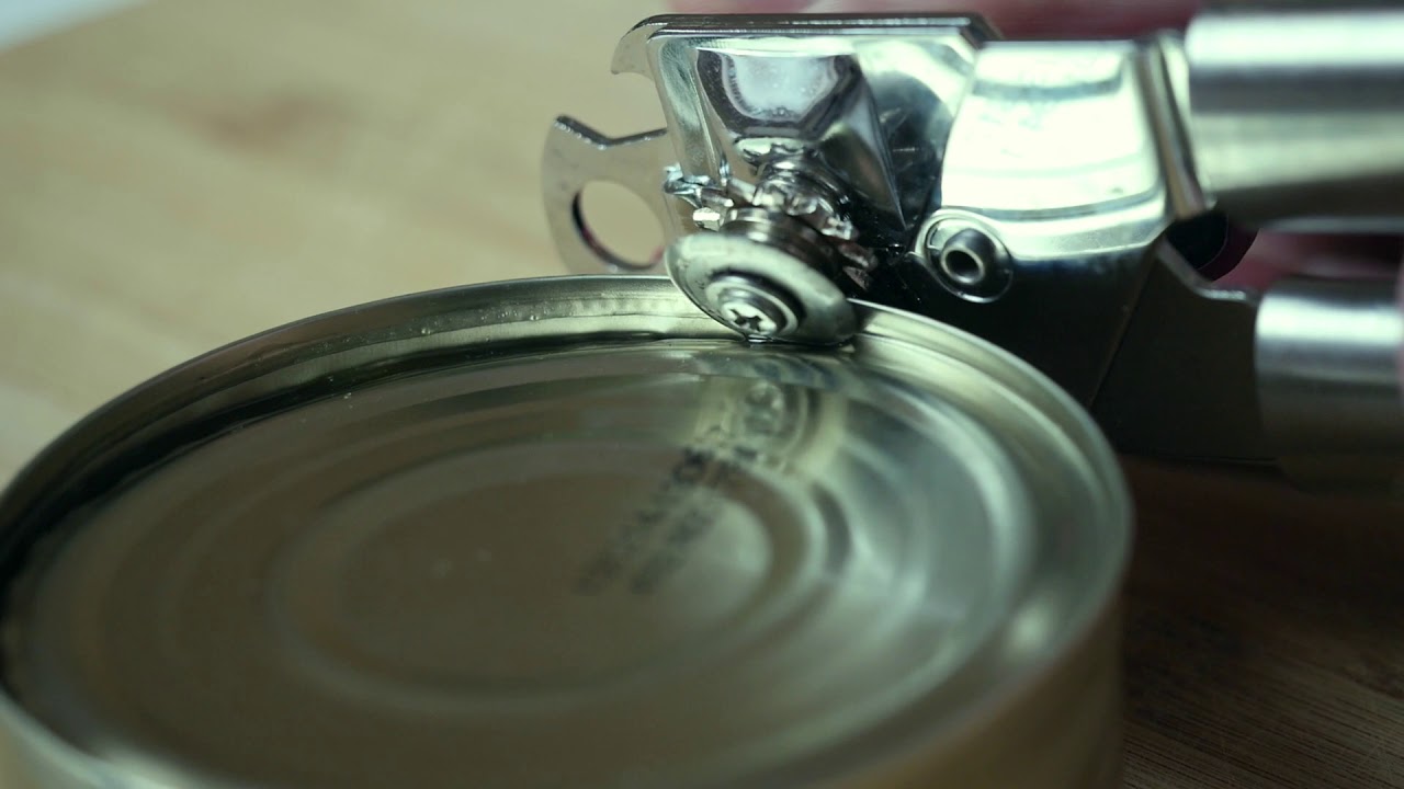 Opening a can of sprat with a rotating wheel opener. Free HD video ...