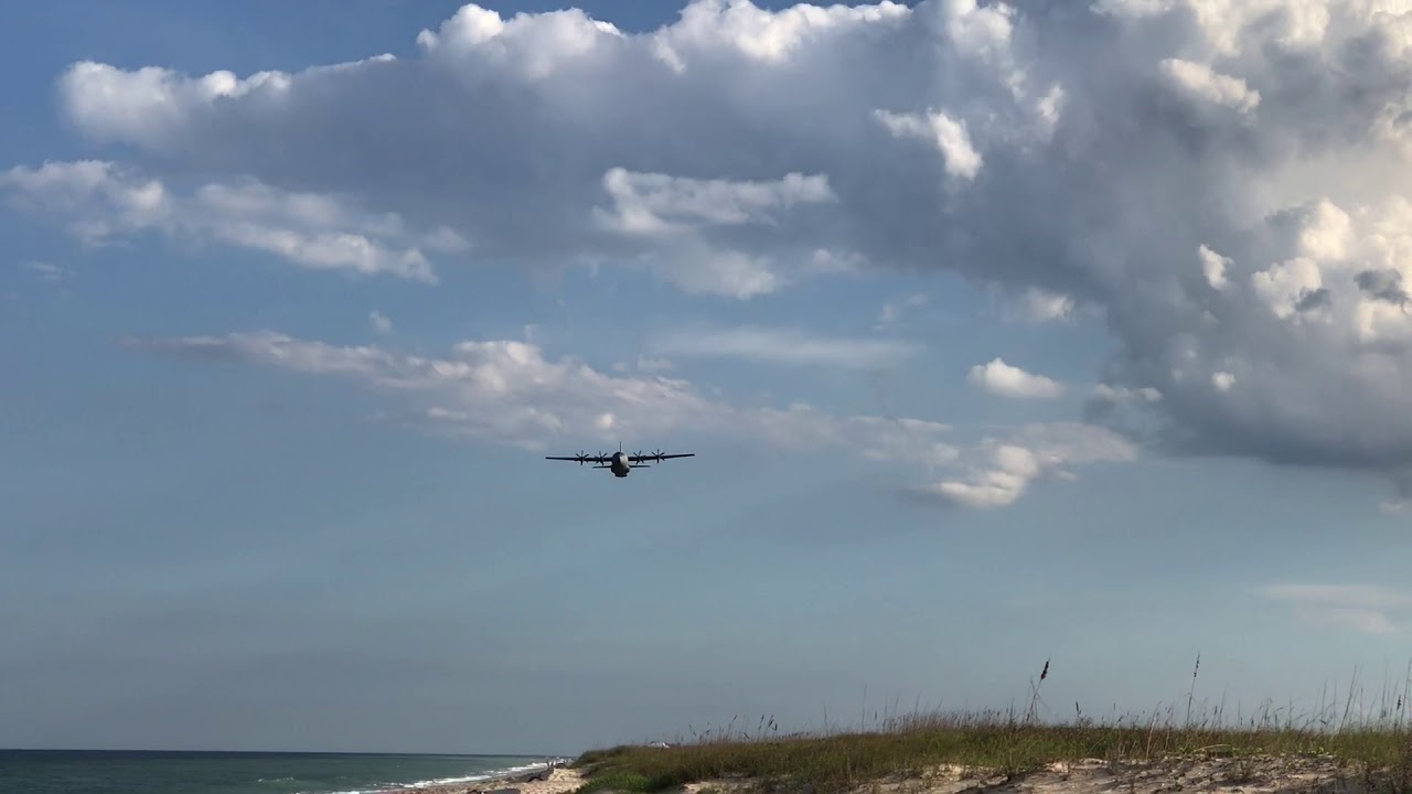 One second of a huge military plane flying over the beach! - YouTube