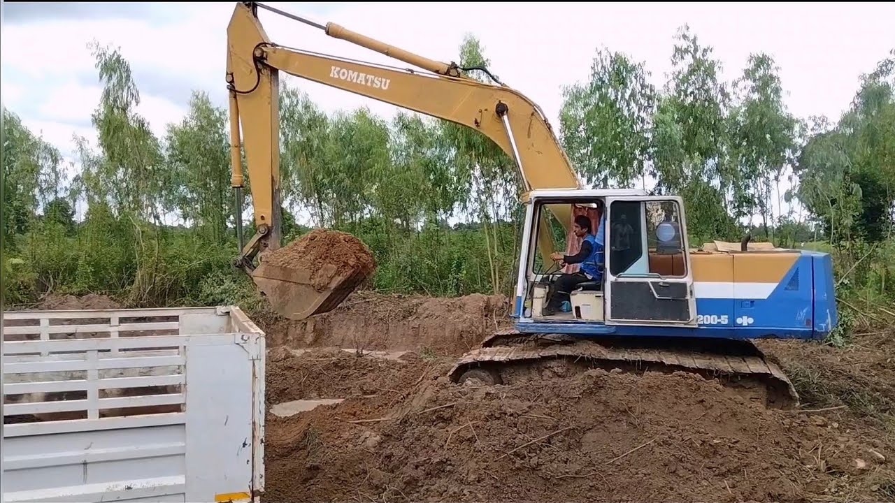 KOMATSU Pc 200-5 load the soil into a 6-wheel truck, a dump truck ...