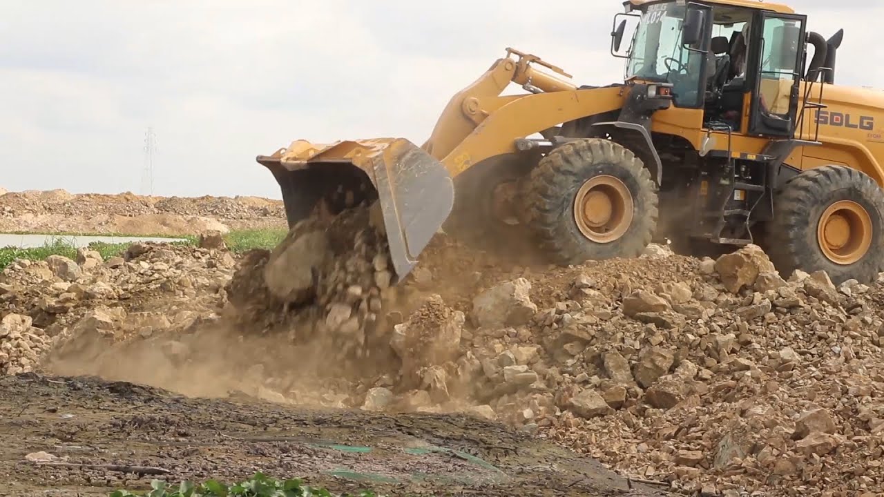 Extremely Wheel loader and Dump truck in operating pushing & unloading ...
