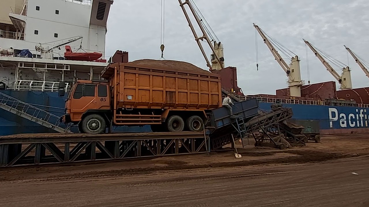 cargo loading palm kernel expeller using truck and conveyor - YouTube