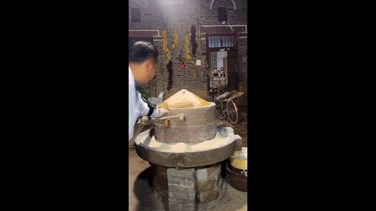 A stone mill for grinding flour, a traditional Chinese food processing ...