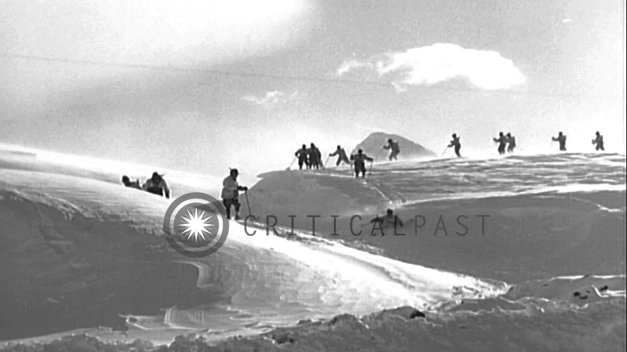 Alpine troops ski down a slope as they carry ammunition in Passo Rolle ...