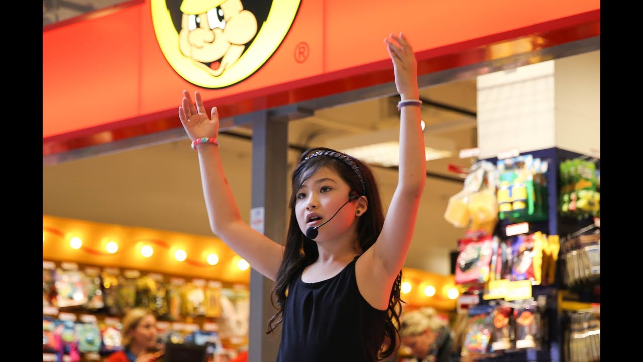 Little girl singing in shopping mall and collecting money for ...