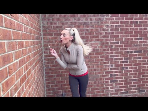 BLONDE GIRL SPITTING ON WALL AND SMOKING 