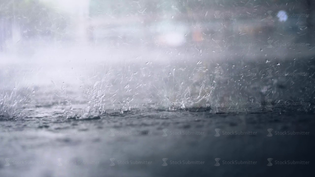 It is raining outside. Rain drops break in a puddle. slow motion. close ...