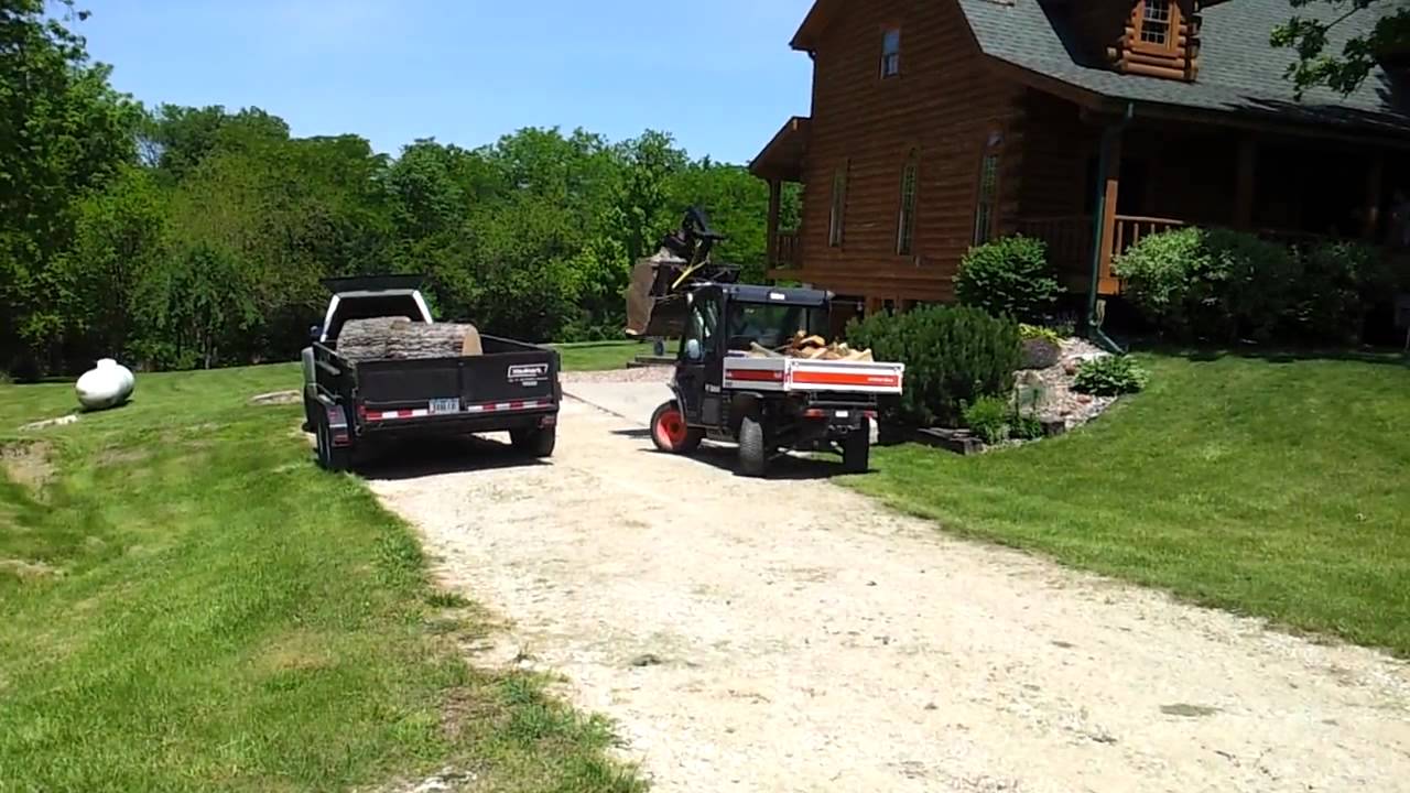 Toolcat moving big rounds logs with grapple - YouTube