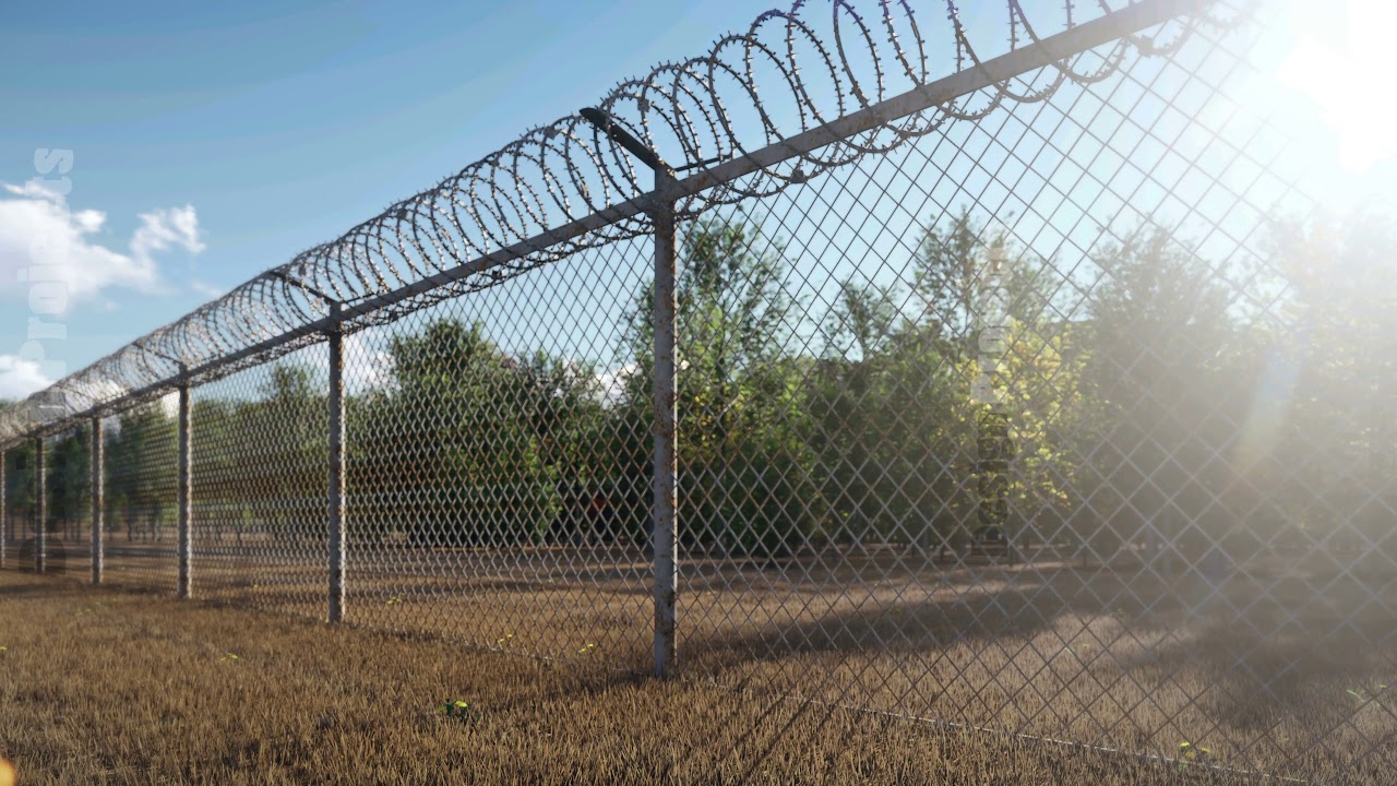 The sun's rays and autumn trees are visible through the metal prison ...