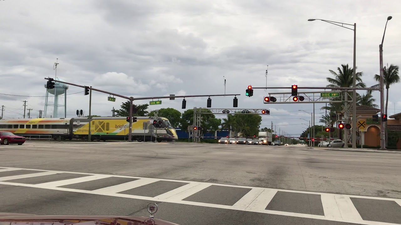 BRIGHTLINE TRAIN BLOWING THROUGH RAPIDLY ON DIXIE HIGHWAY IN DEERFIELD ...