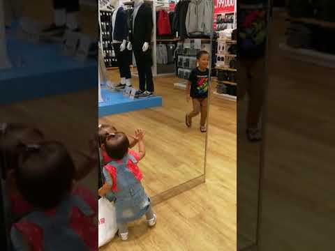 Anak kecil cium dirinya di cermin