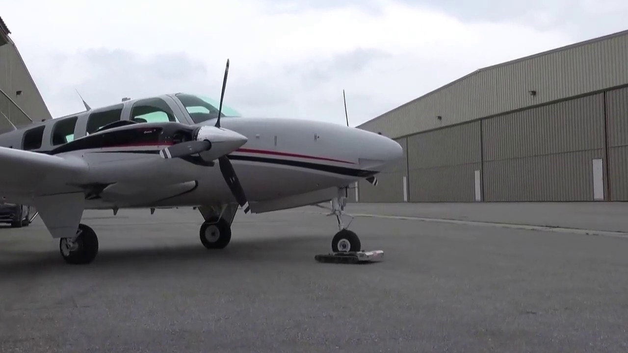 Twin engine Beechcraft Baron being towed by tug - YouTube