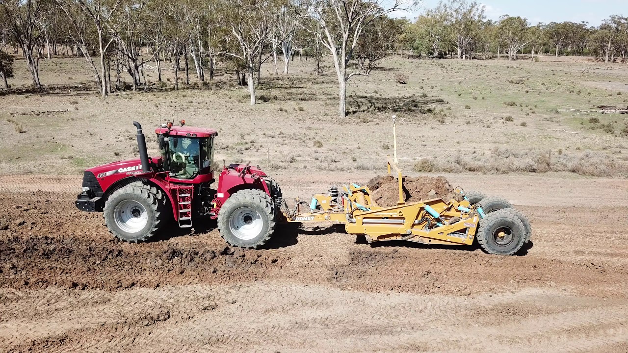 TOOMEY 4000B Scraper behind an STX450 unloading clay onto a water ...