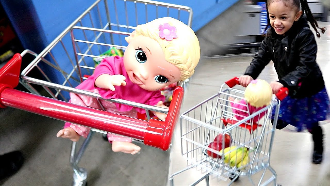 Cute Little Girl Doing Shopping at The Supermarket with her Baby Doll ...
