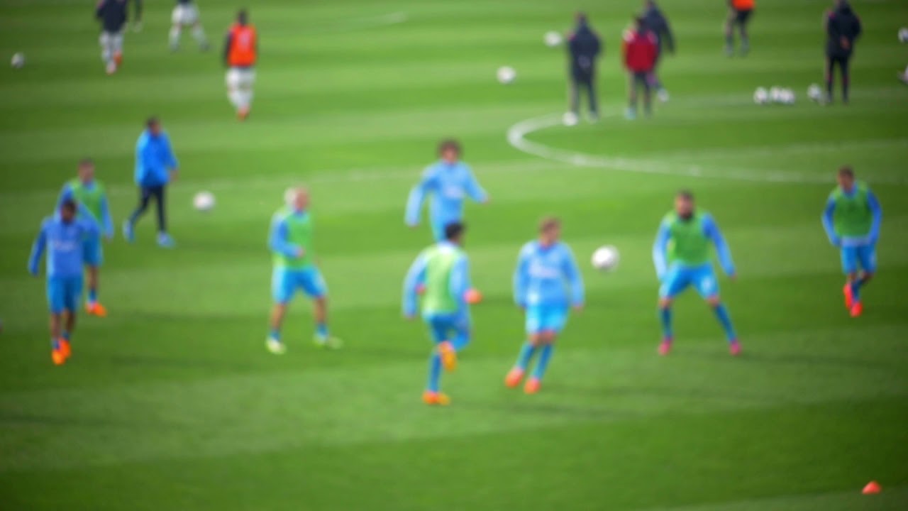 defocused slow motion shot of football players warm up before the game ...