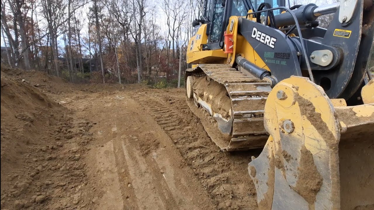 filling in a silt pond with john deere track loader - YouTube