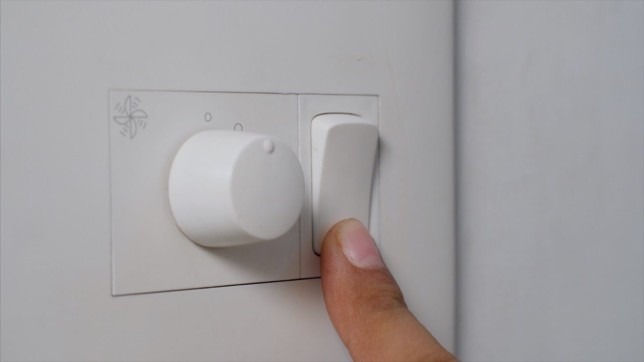Closeup shot of a man switching the fan on and turning on the ...