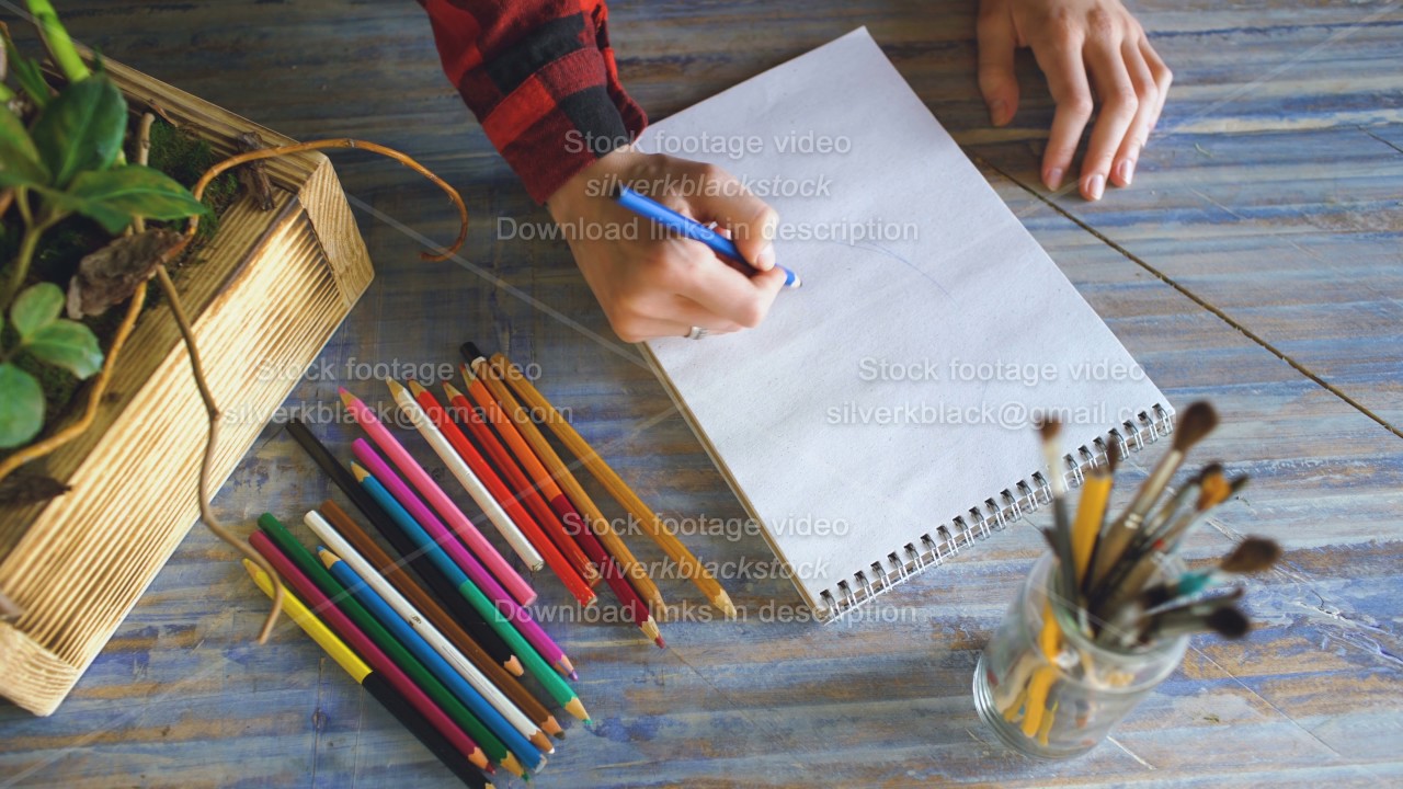 Young woman artist painting scetch on paper notebook with pencil ...