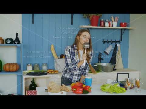 Crazy funny girl dancing and singing in the kitchen while cooking breakfast at home in the morning