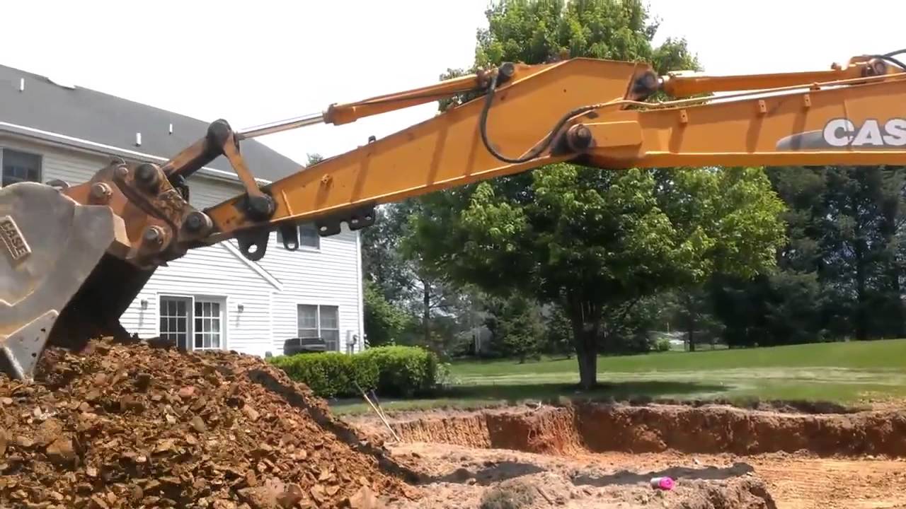 Case track hoe digs swimming pool digging in dirt pilesdump trucks ...