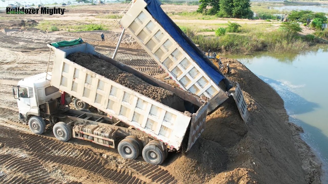 Nice Showing Action Bulldozer Working, Dozer push sand into the water, Long Dump Truck Unloading ...