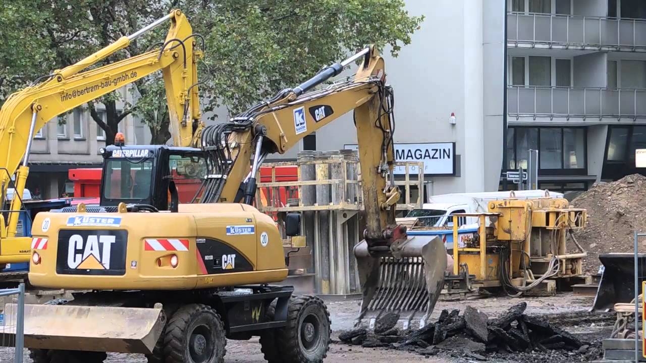 Bagger Caterpillar M313D Verstellausleger super Operator an den Sticks ...