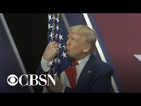 Trump hugs and kisses the American flag at CPAC 2020
