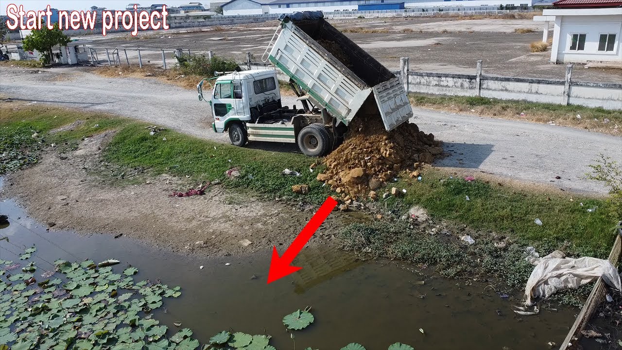 First truck dumping stone to start up project pouring into the lake ...