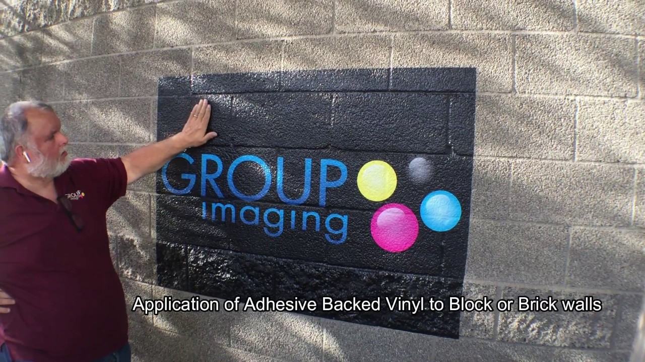 Applying adhesive graphics on block and brick and stucco - YouTube