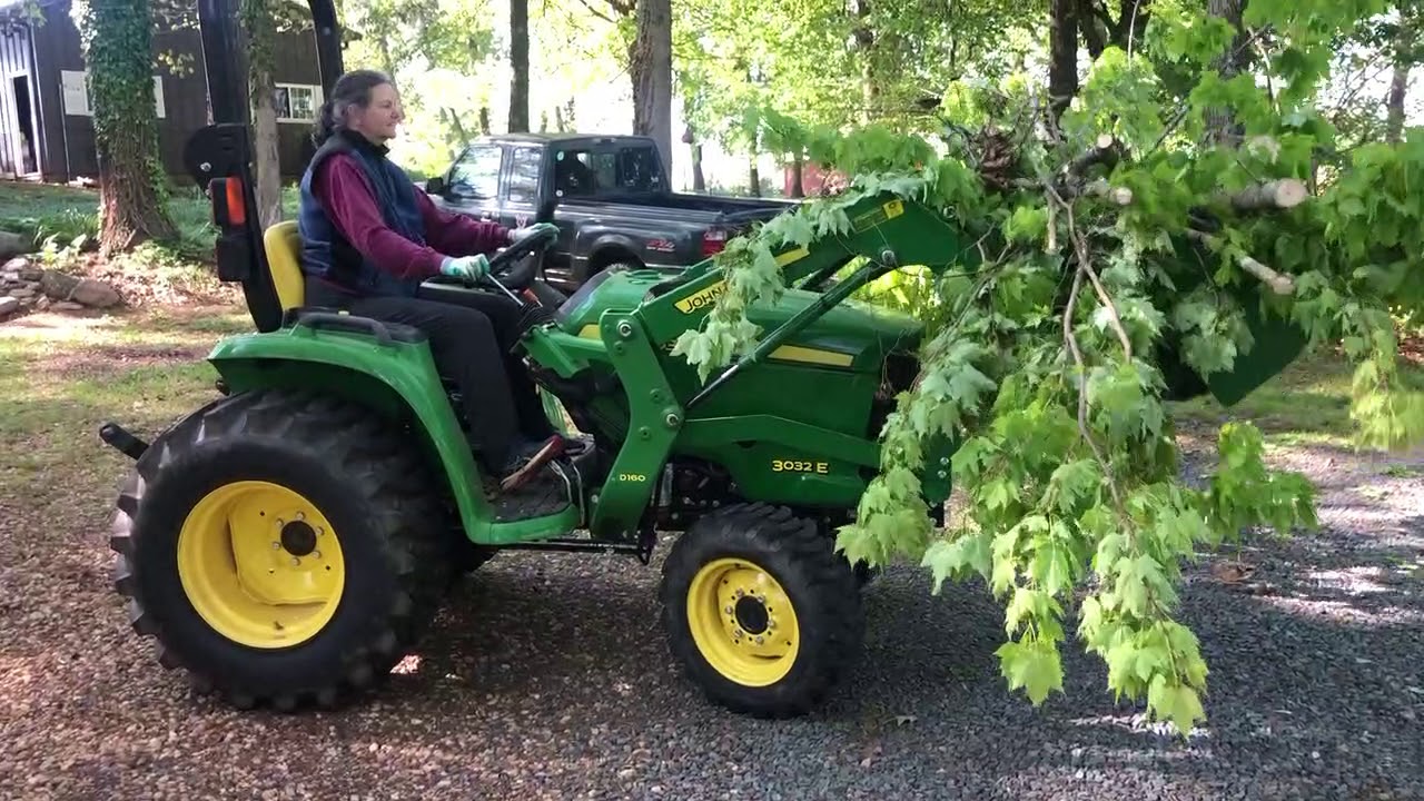 Grandma driving the tractor and learning to move the bucket up and down ...