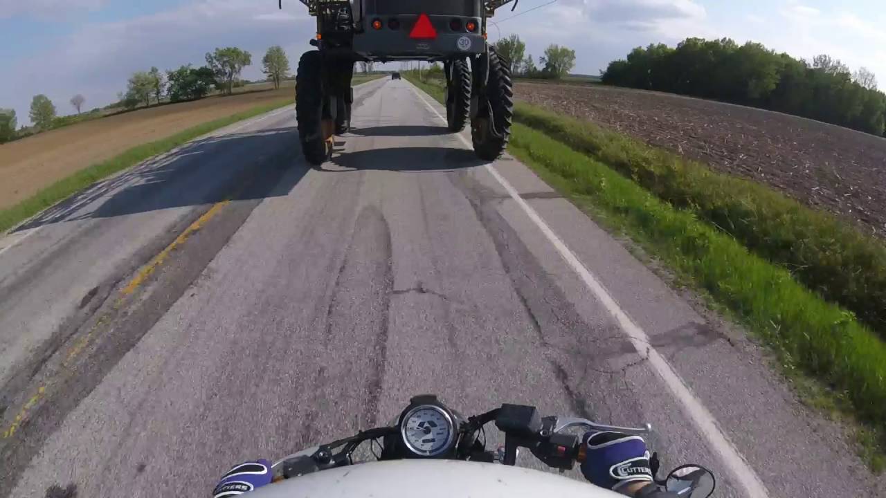 motorcycle drives under tractor sprayer - YouTube