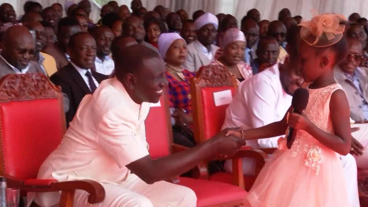 A bold young girl takes President Ruto by the hand and guides him to ...