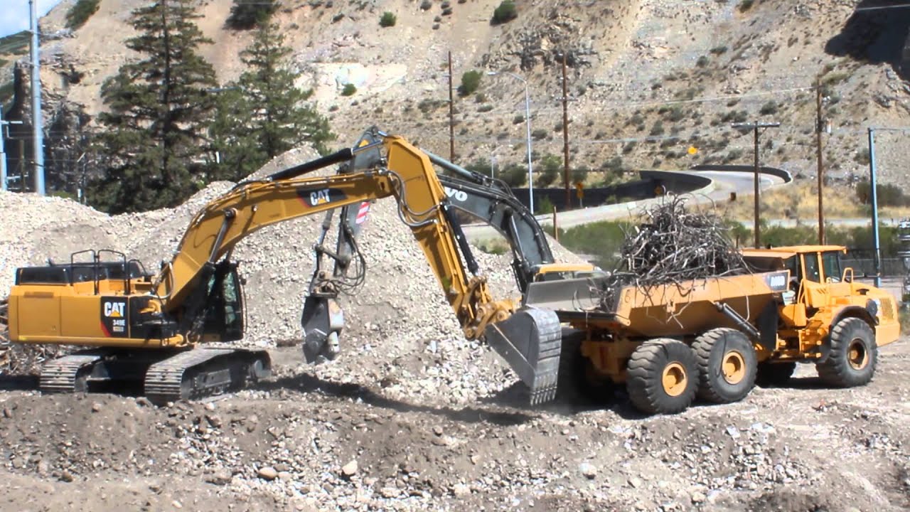 CAT and Volvo Excavator loading a dump truck with scrap rebar - YouTube