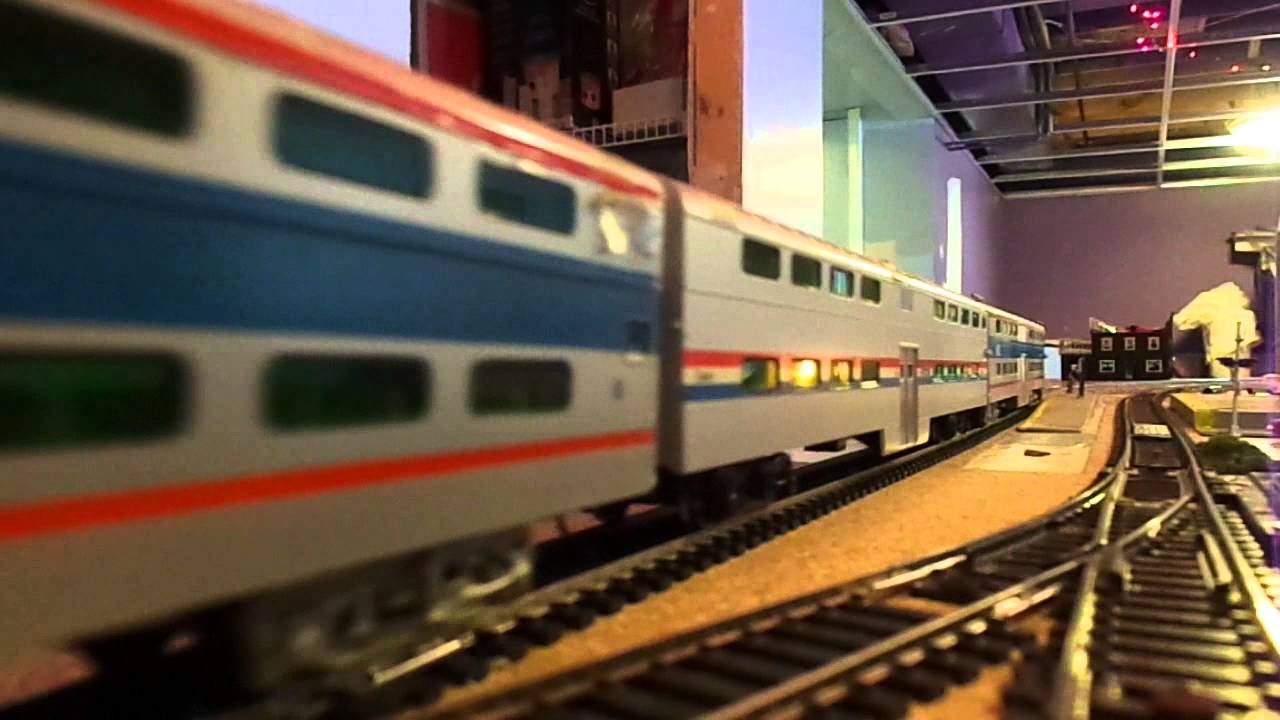 HO-Scale New Mexico Rail Runner MP36PH-3C 109 leads a train of Bi ...