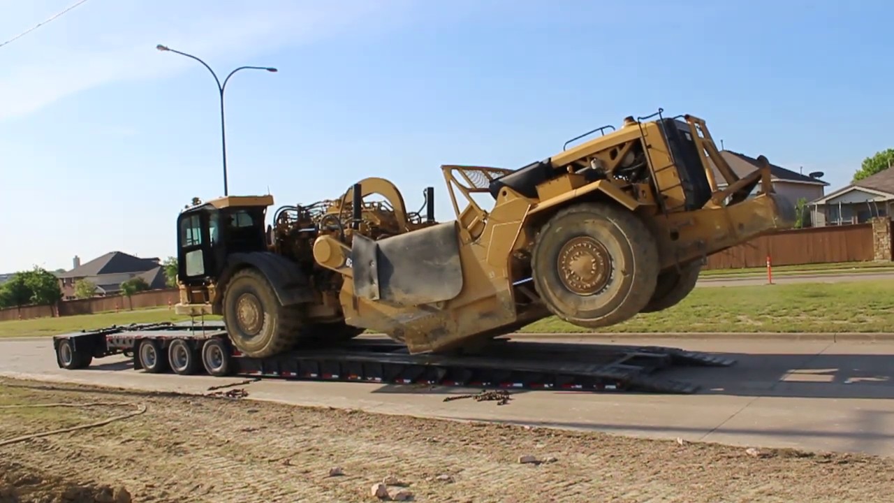 Cat 627H being loaded and raised for transport on a lowboy. - YouTube