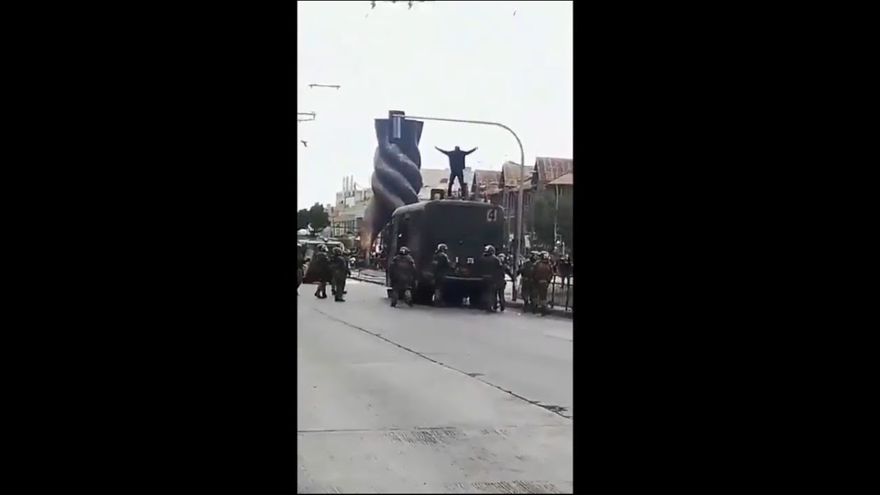 Chile: Daring protester taunting cops on top of a riot police bus ...