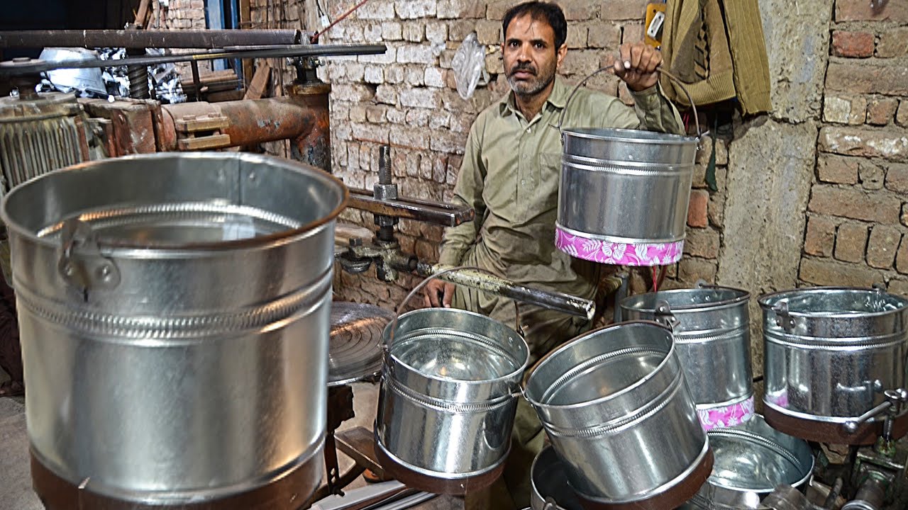 A skillfull man has amazing talent of making steel bucket from steel ...
