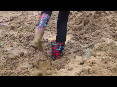 Girl in rubber boots stuck in mud