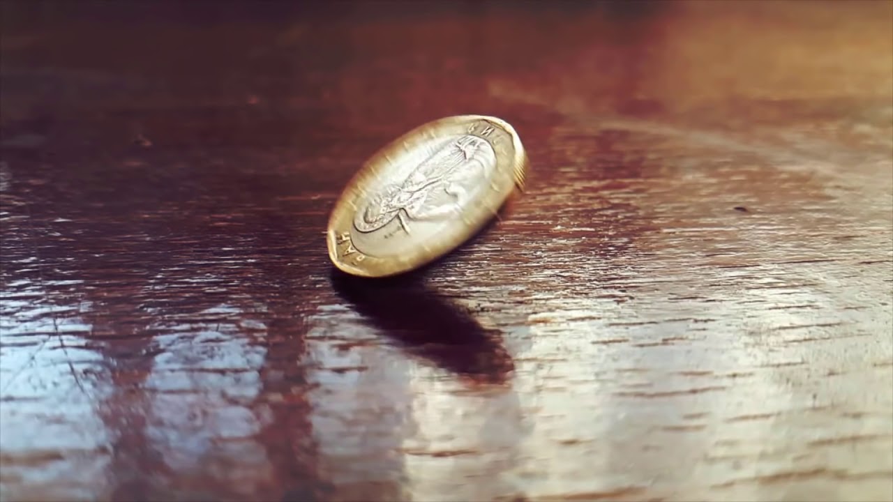 Gold Coin Spins on a Table in Slow Motion - YouTube