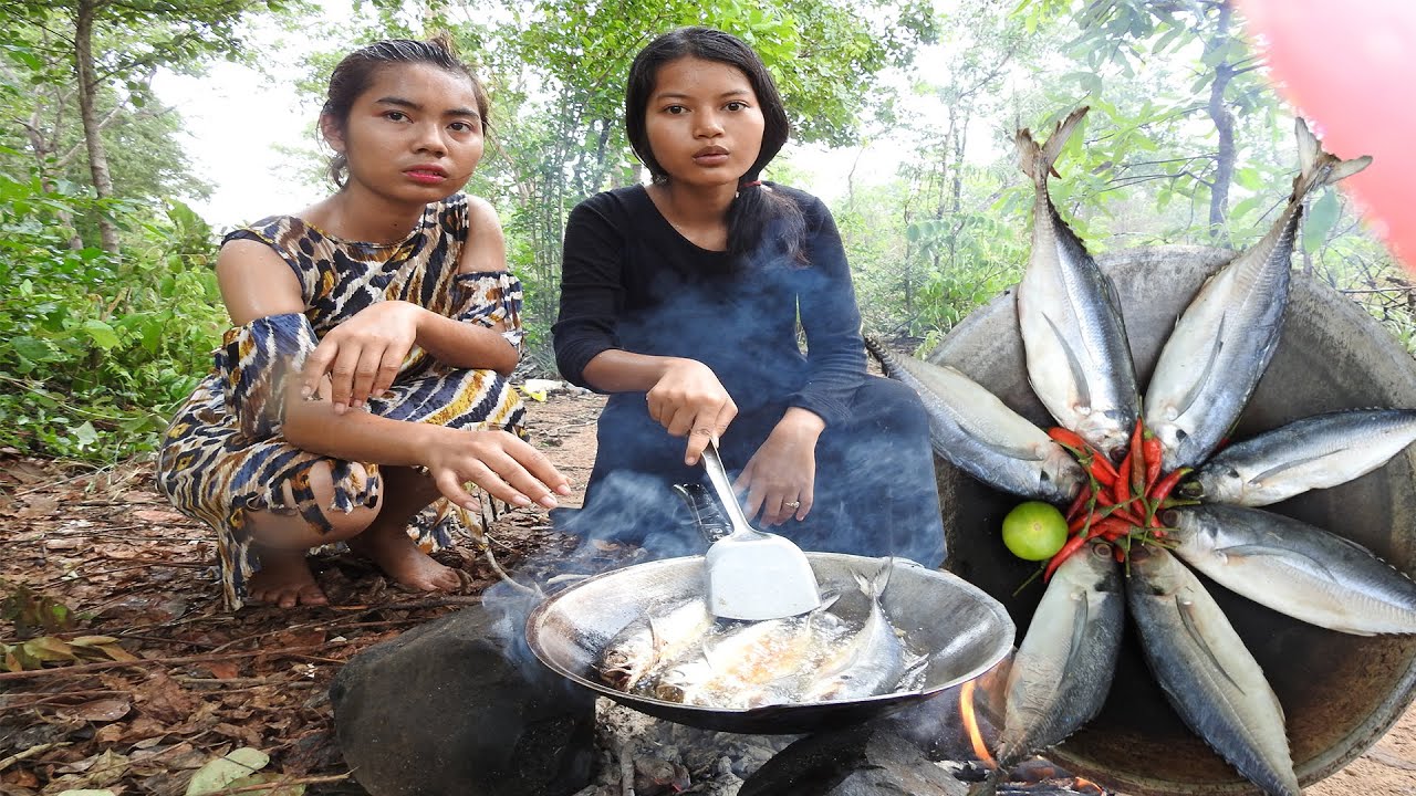 Beautiful girl cook sea fish in forest and eating delicious in rain ...