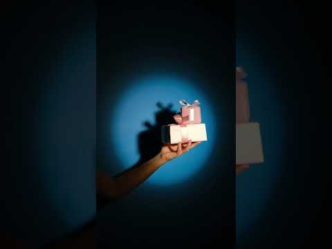 Hand Carrying Two Gifts in Spotlight Setting With Blue Background ...