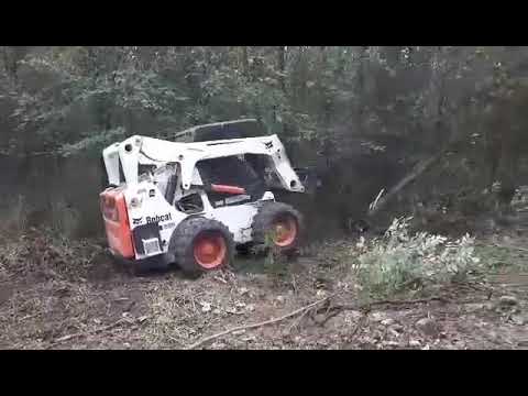 Bobcat machine skid loader cutting trees to widen a farm entrance - YouTube